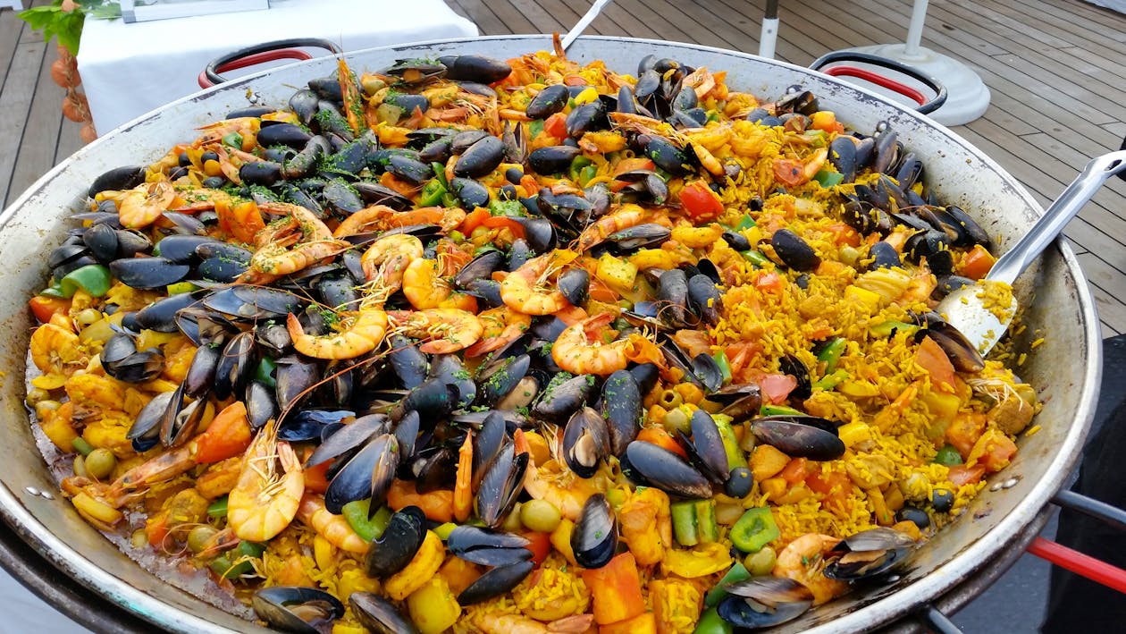 Close-up of a large pan of colorful seafood paella outdoors