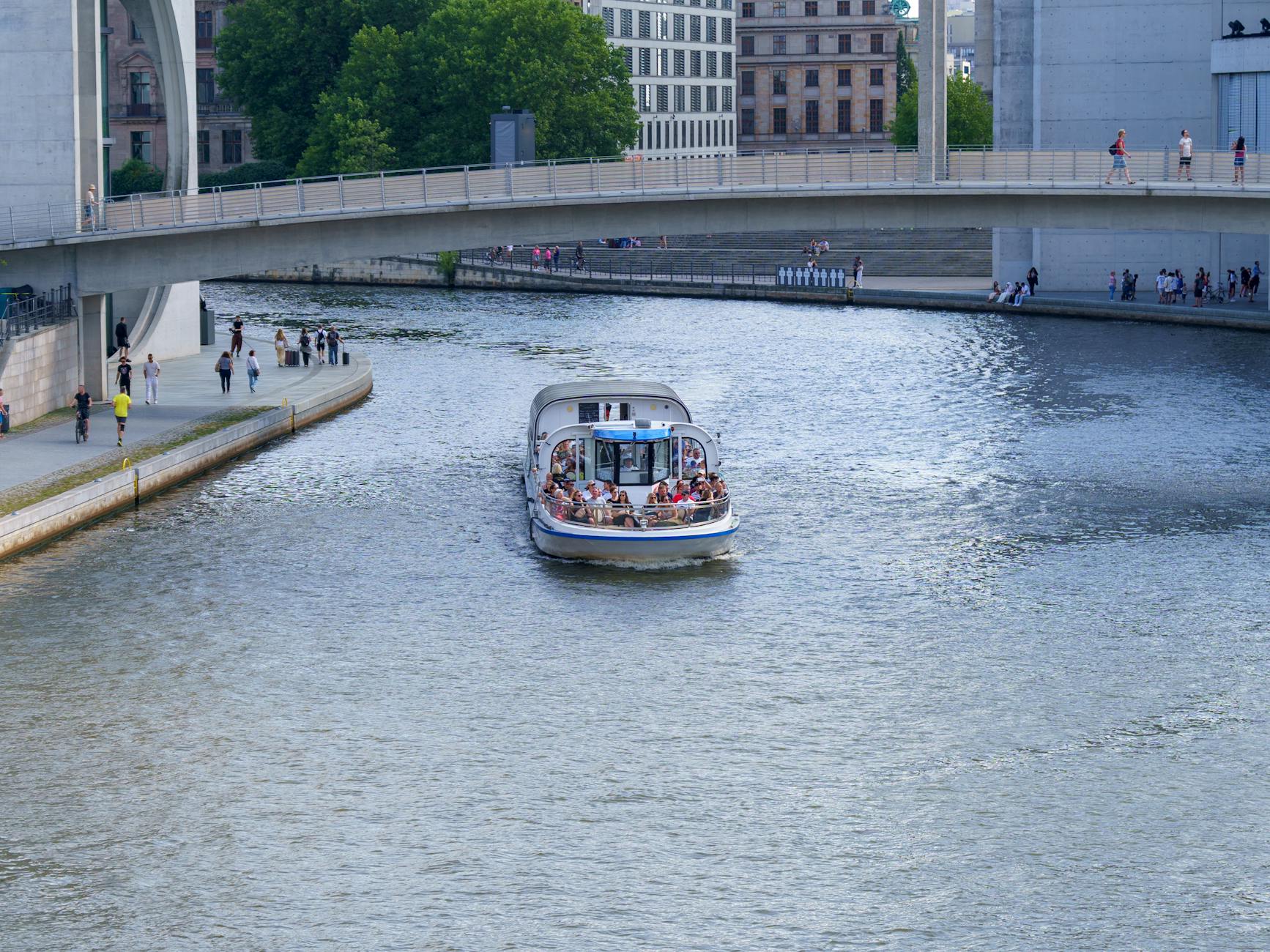 A boat cruising under a modern bridge in Berlin