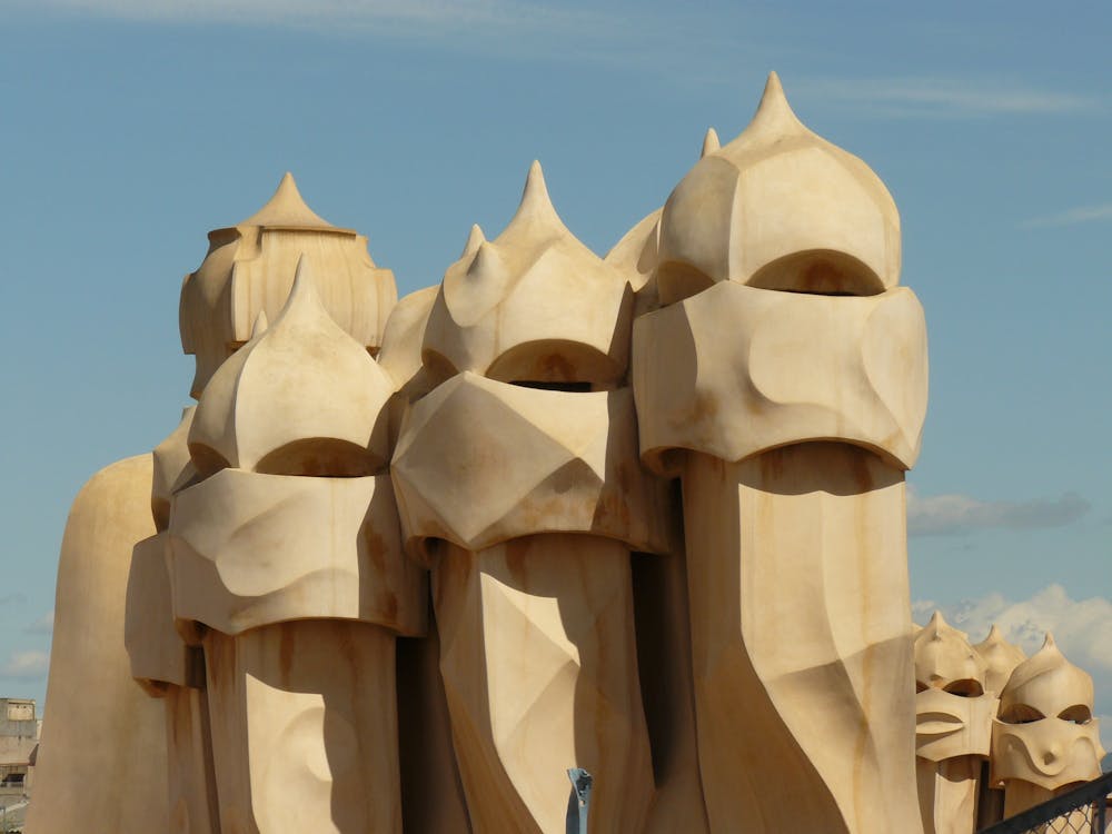 Artistic chimneys of Casa Mila by Gaudi in Barcelona set against a clear sky