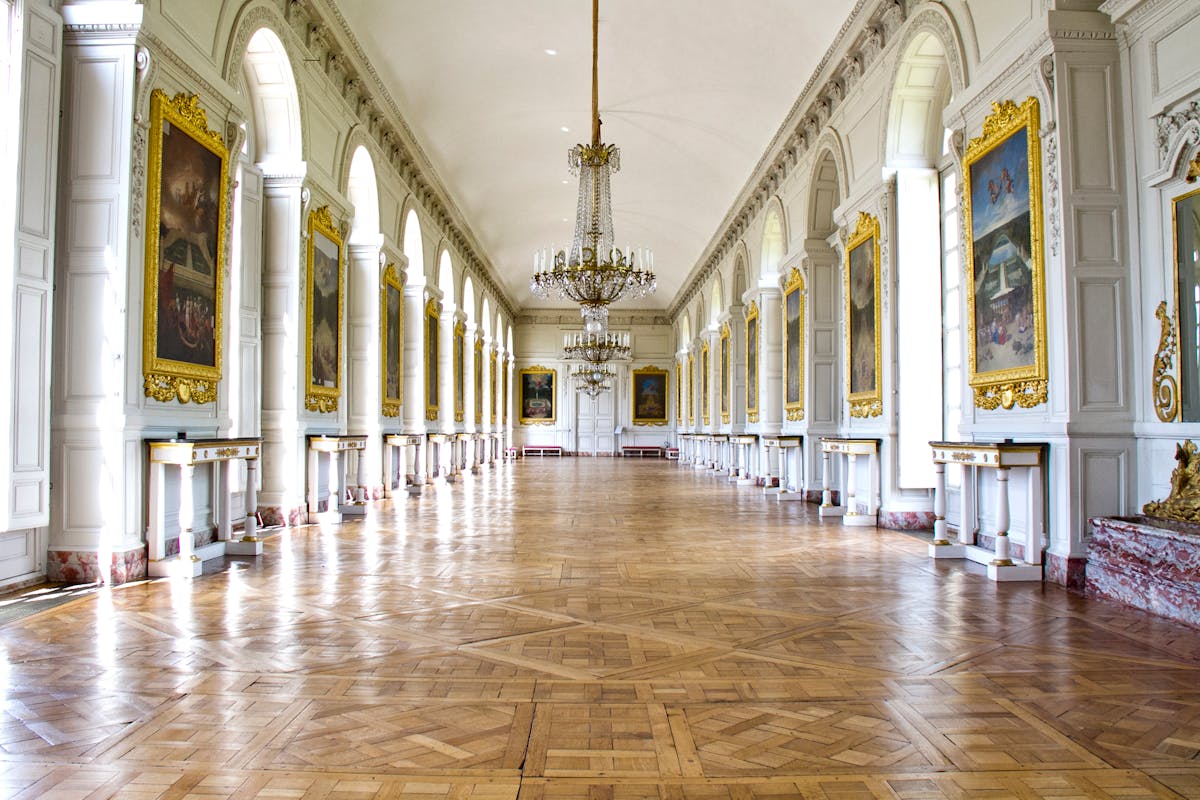 Elegant hallway of the Grand Trianon with crystal chandeliers at Versailles