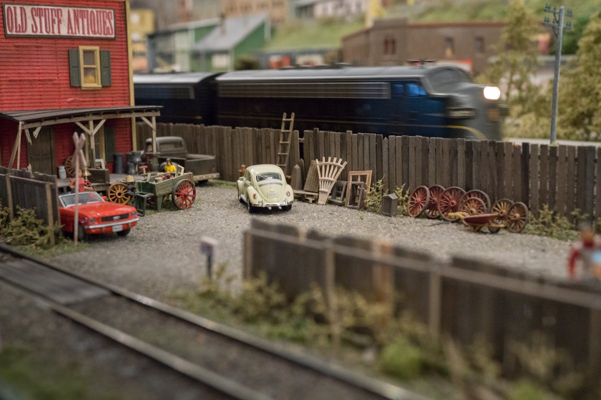 Detailed model train diorama with vintage cars and antique shop