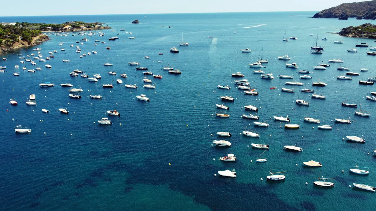 Scenic aerial view of numerous boats in the azure waters of Cadaques Spain