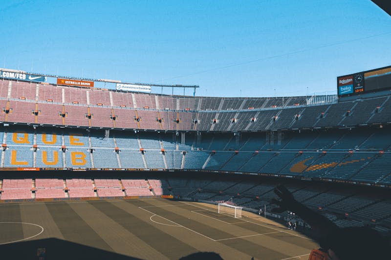 Wide shot of the empty Camp Nou stadium in Barcelona showing the pitch and stands