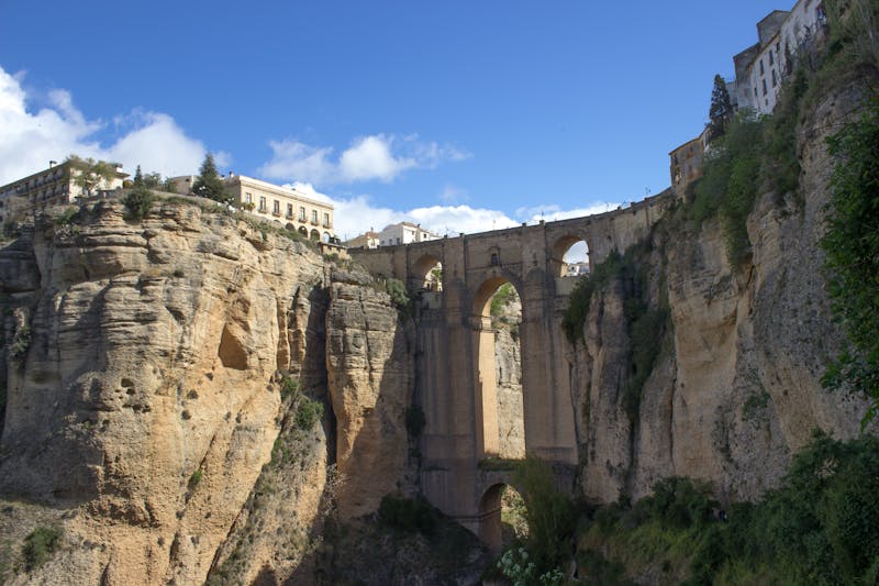 View of the Puente Nuevo bridge from a distance showing the dramatic gorge and Ronda buildings