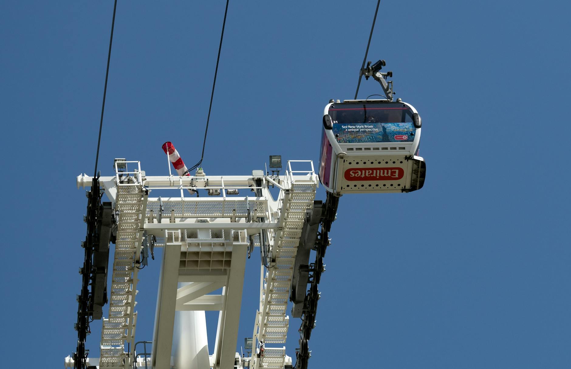 The Emirates Air Line cable car gondola crossing high above the River Thames with the London skyline in the background