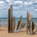 The Les Braves Memorial sculpture standing on the sands of Omaha Beach in Normandy