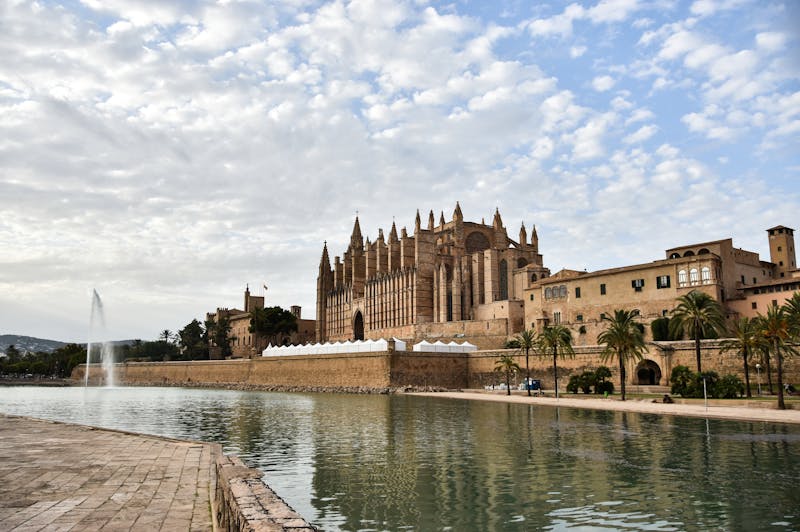 Cathedral de Mallorca by the waterfront under a cloudy sky