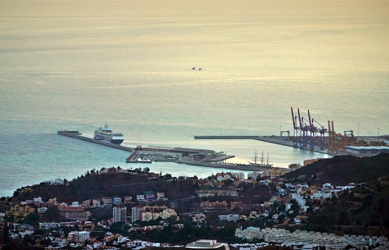 Aerial photograph of Malaga port and coastline glowing in warm sunset light