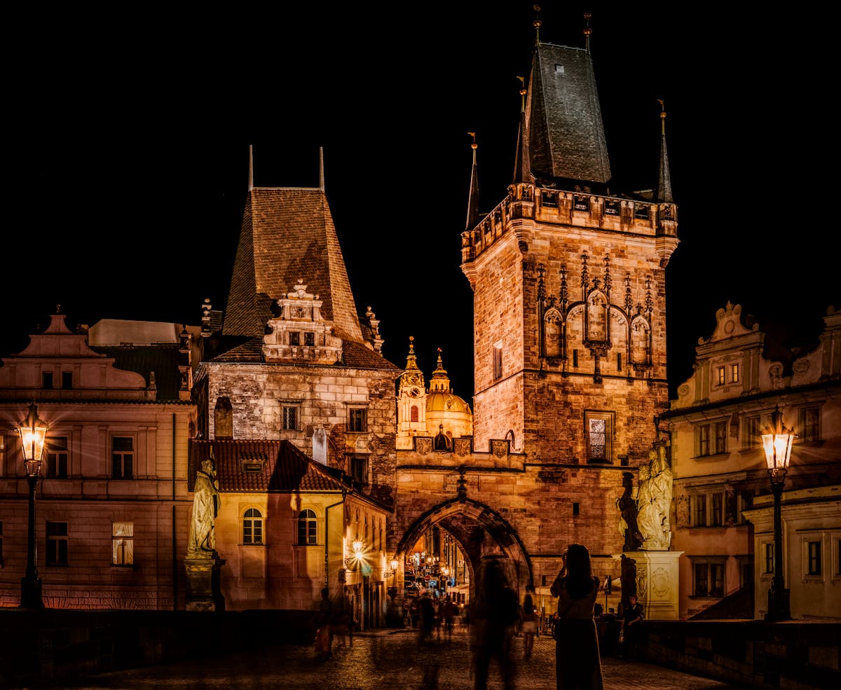 Ornate Gothic building in Prague lit up dramatically against the night sky