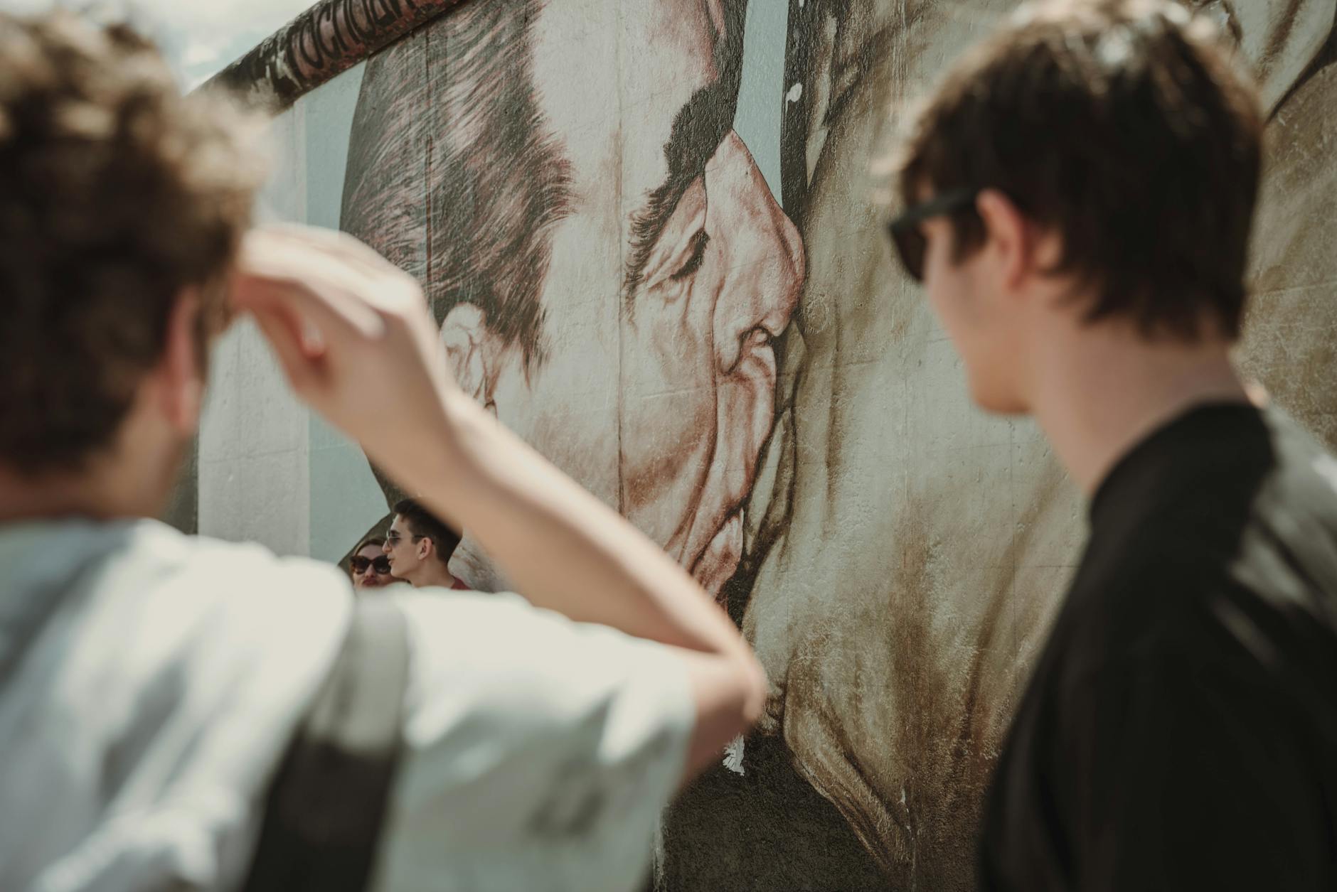 Visitors viewing the Berlin Wall murals up close
