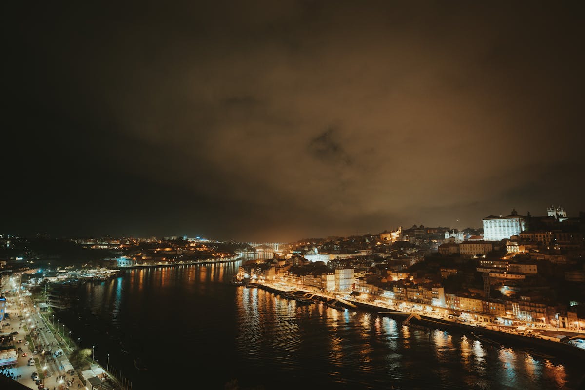 Porto cityscape at night with the Dom Luis I Bridge and riverbanks illuminated