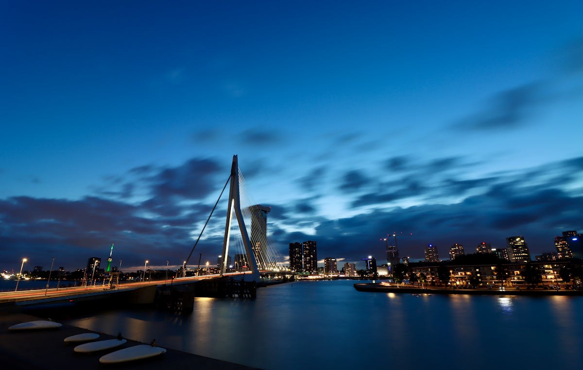 The Erasmus Bridge and Rotterdam skyline at twilight with reflections on the Maas River