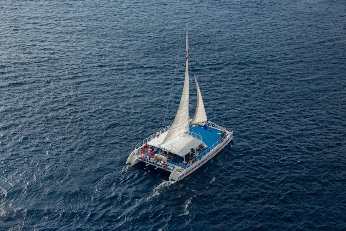 Aerial shot of a catamaran full of passengers sailing on clear blue Mediterranean waters