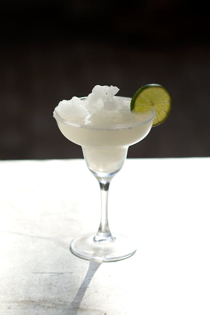 Chilled frozen margarita in a glass garnished with lime
