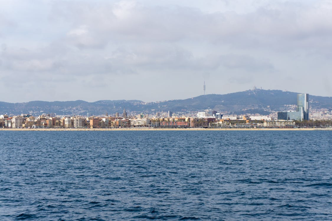 Panoramic view of Barcelona coastline with urban skyline and distant hills from the sea