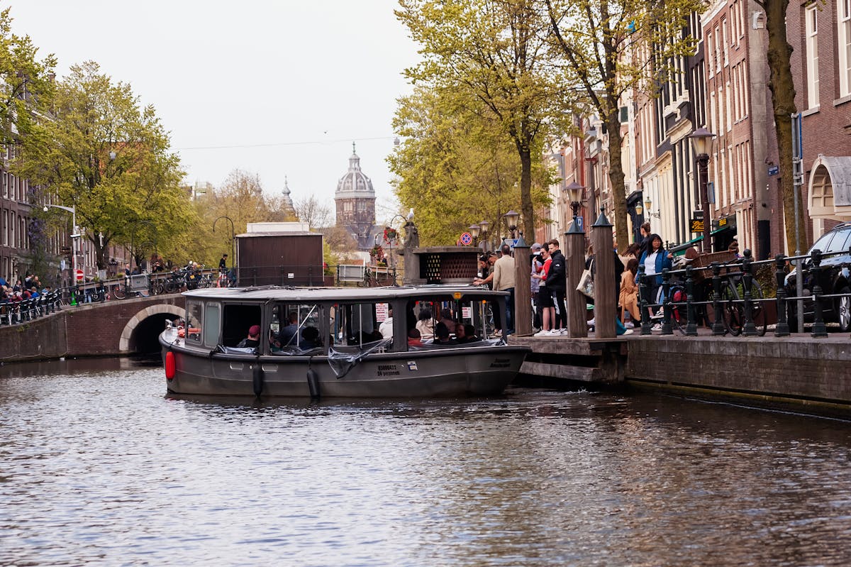 Sightseeing boat passing under a bridge on an Amsterdam canal
