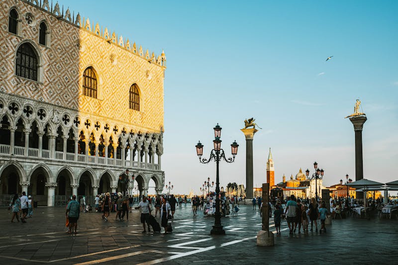 Sunset view of Piazza San Marco showing the Doges Palace and visitors in the square