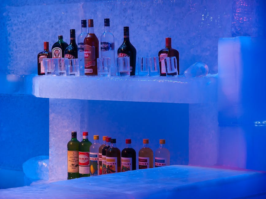 Vibrant display of liquor bottles and glasses on an ice bar counter