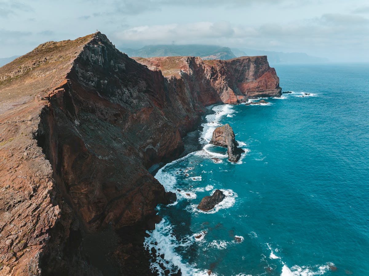 Aerial view of Madeira island rugged cliffs meeting the Atlantic Ocean