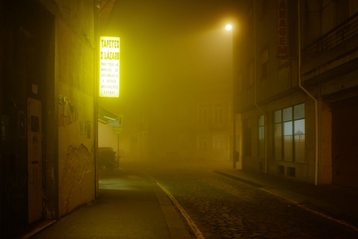A misty atmospheric street in Porto with warm lighting at night
