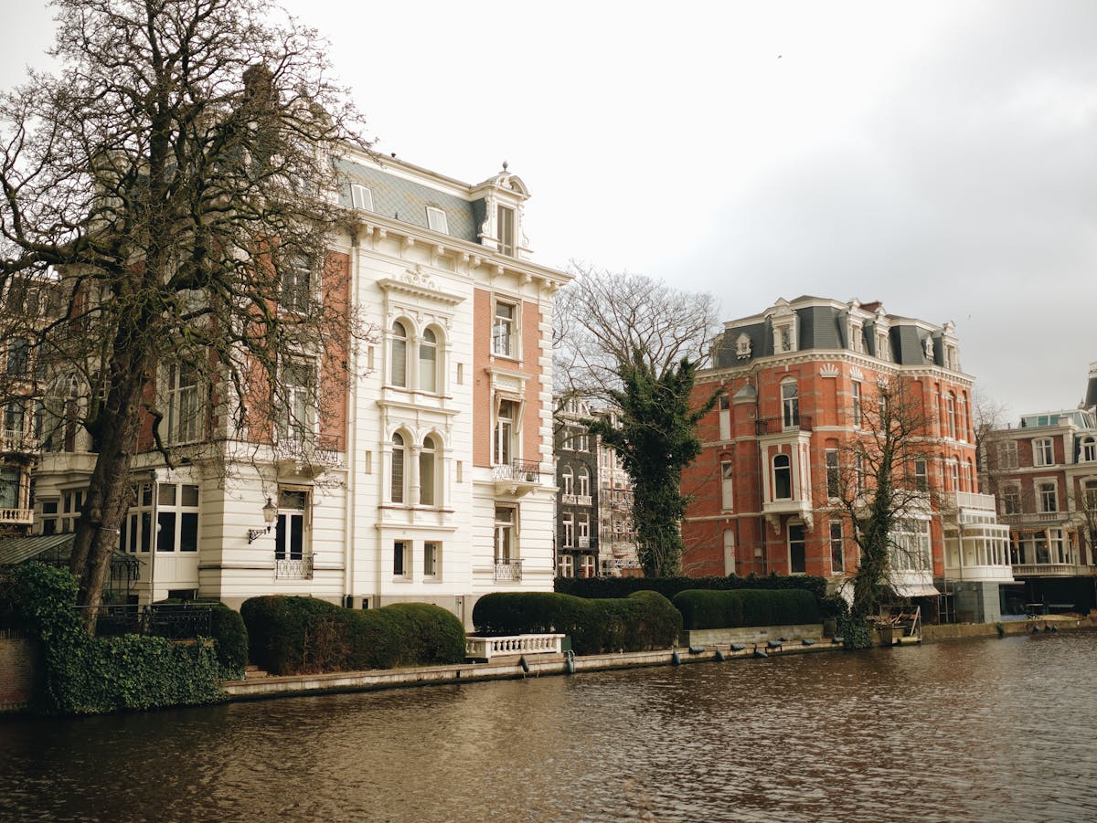 Charming 17th-century mansions lining an Amsterdam canal on a sunny day