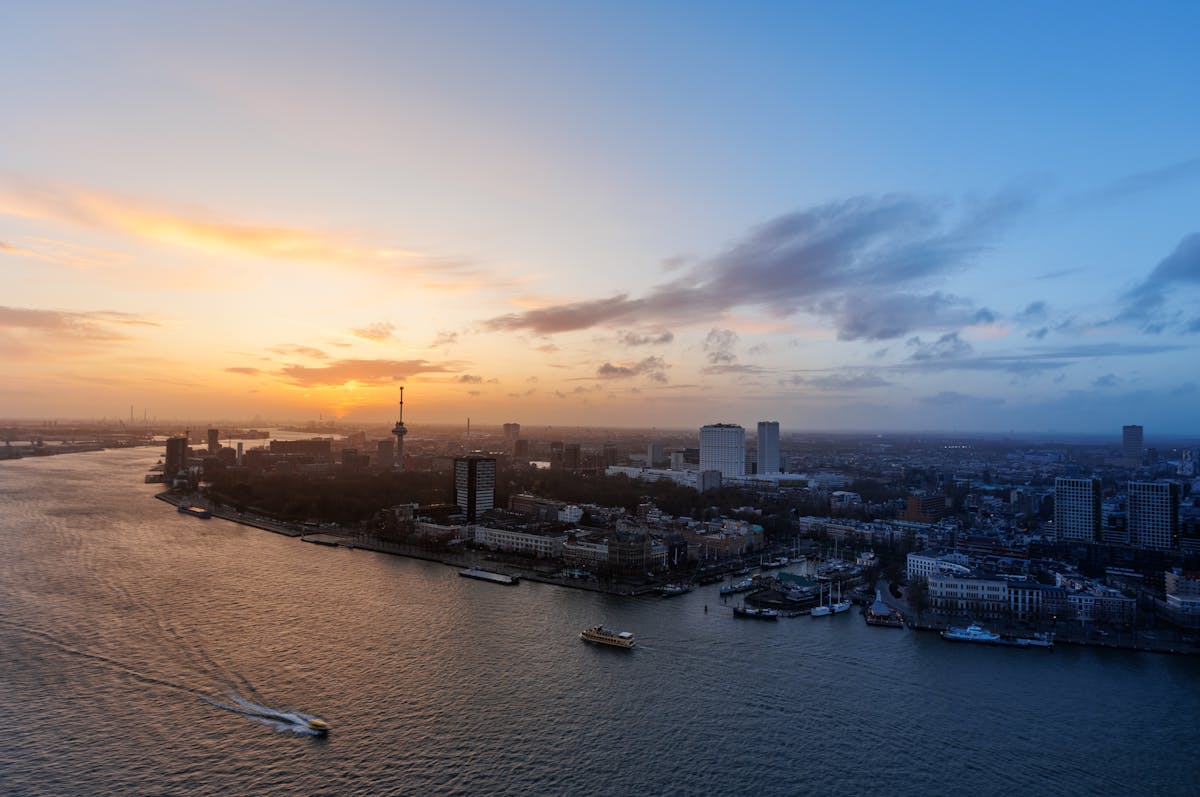 Aerial photograph of Rotterdam skyline at sunset showing the Euromast tower and city harbor