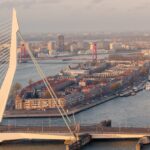 The Erasmus Bridge connects north and south Rotterdam across the Maas River with city skyline in background
