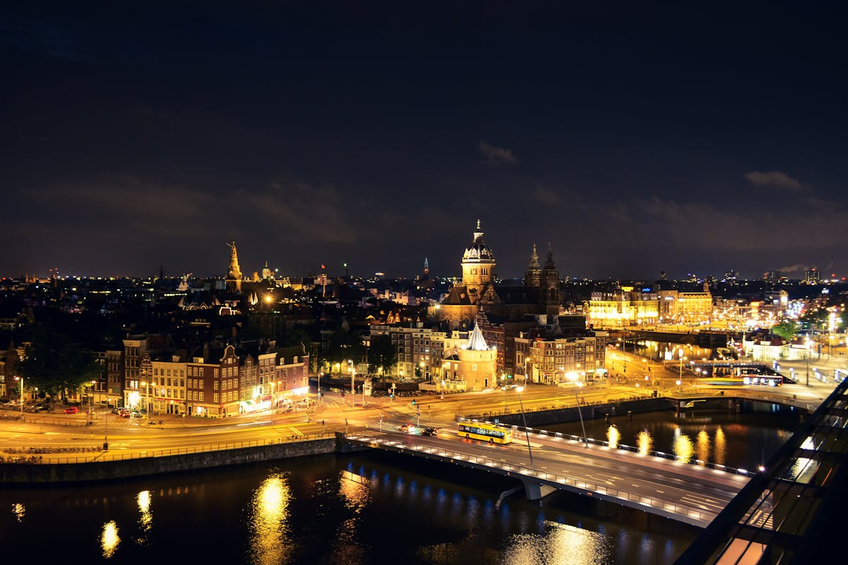 Amsterdam canal at night with illuminated buildings and their reflections on the water