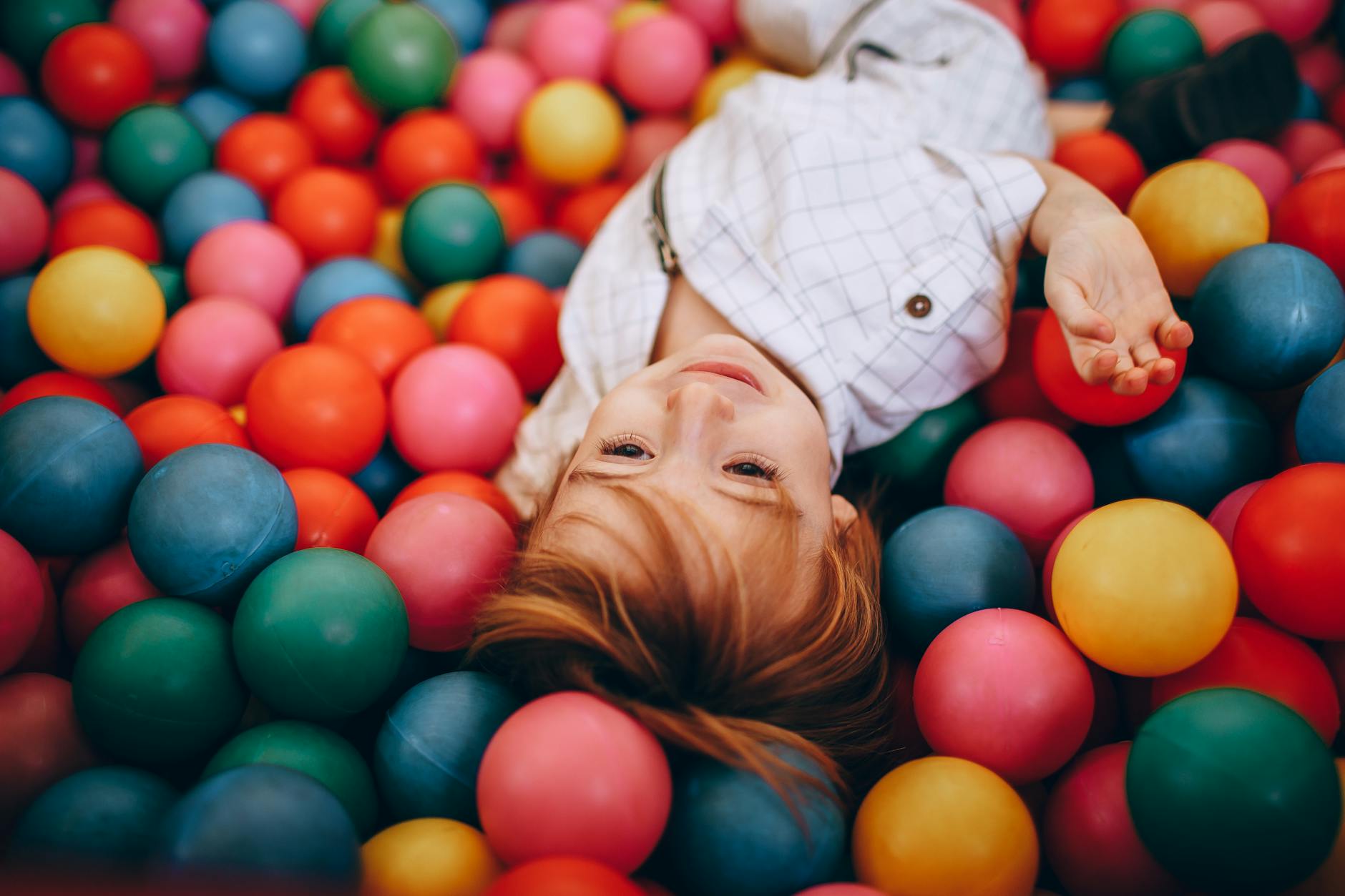 Adorable child having fun in a colorful indoor ball pit