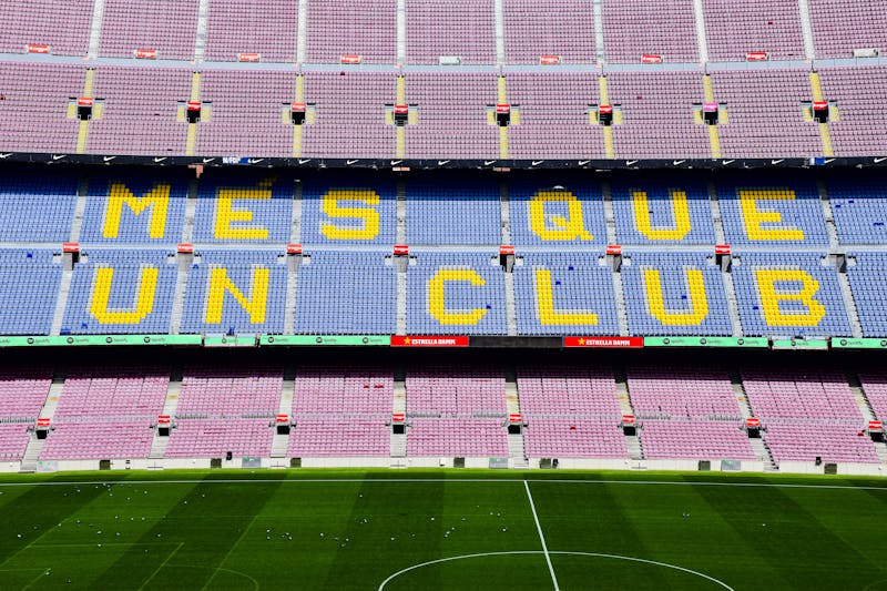 The iconic Mes Que Un Club slogan displayed on seats at Camp Nou stadium in Barcelona