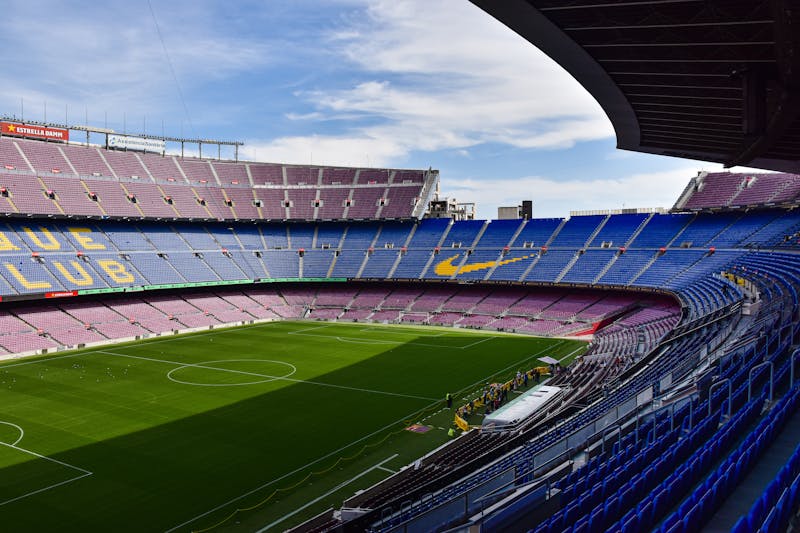 Wide angle view of the empty Camp Nou stadium in Barcelona with blue seats and green pitch