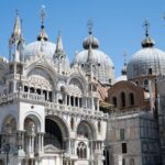 The domes and ornate facade of St Marks Basilica in Venice Italy