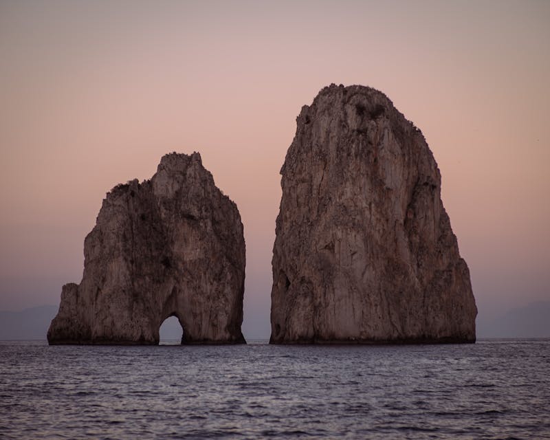 Sunset view of the iconic Faraglioni rocks off the coast of Capri Italy