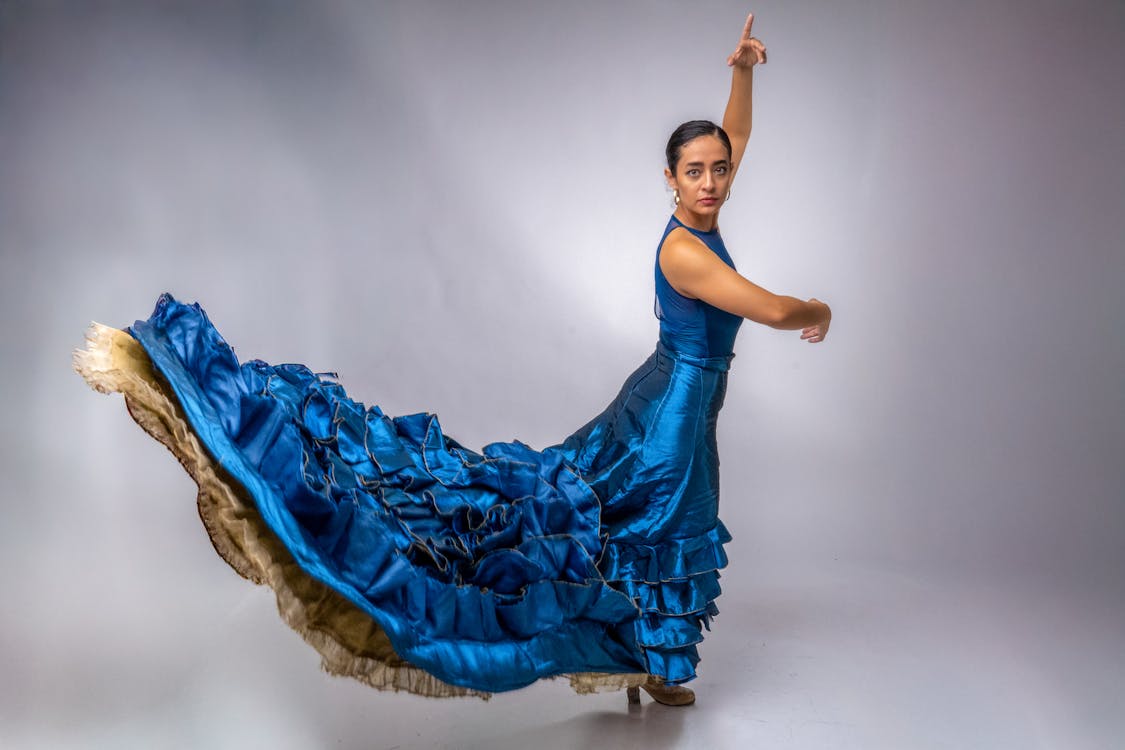 A flamenco dancer performing in a flowing blue dress with dramatic movement