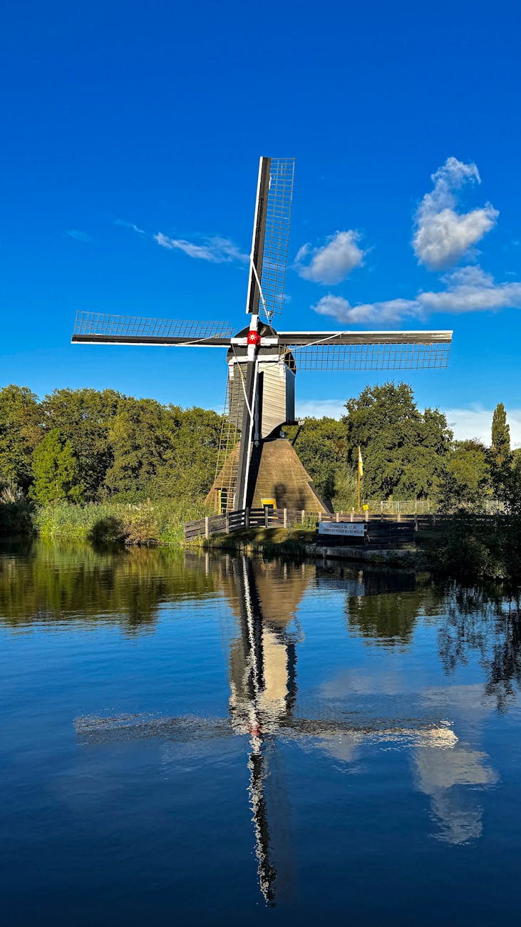 Traditional Dutch windmill reflected in water in the Netherlands