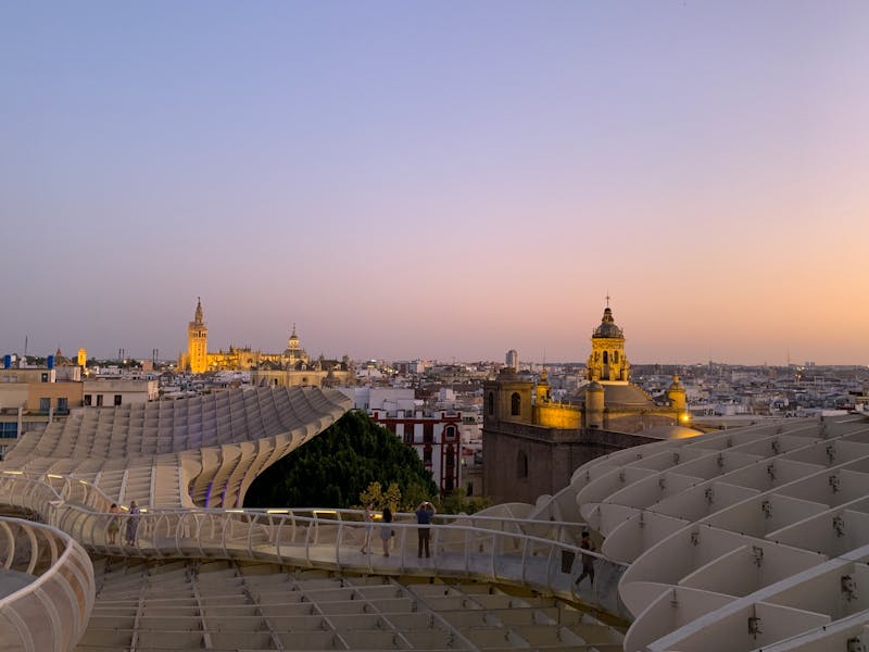 Panoramic sunset view of Seville skyline featuring Metropol Parasol and cathedral