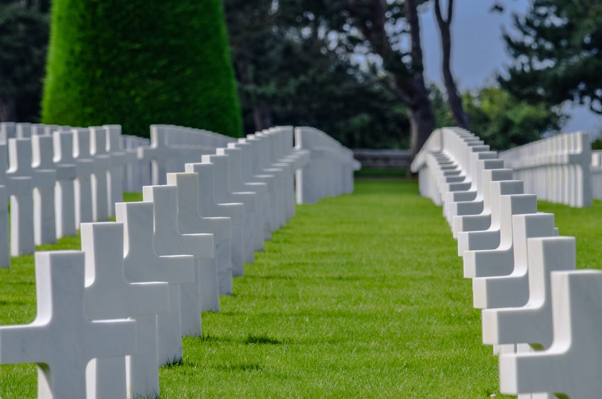 Rows of white crosses in a military cemetery honoring WWII soldiers in Normandy