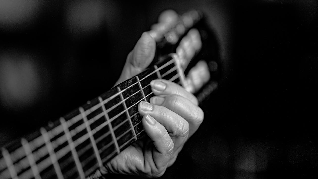 Close-up of a guitarist fingers on the strings of an acoustic guitar