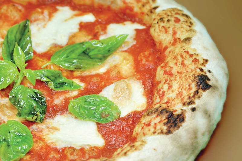 Close-up of a freshly baked Neapolitan Margherita pizza with mozzarella and basil