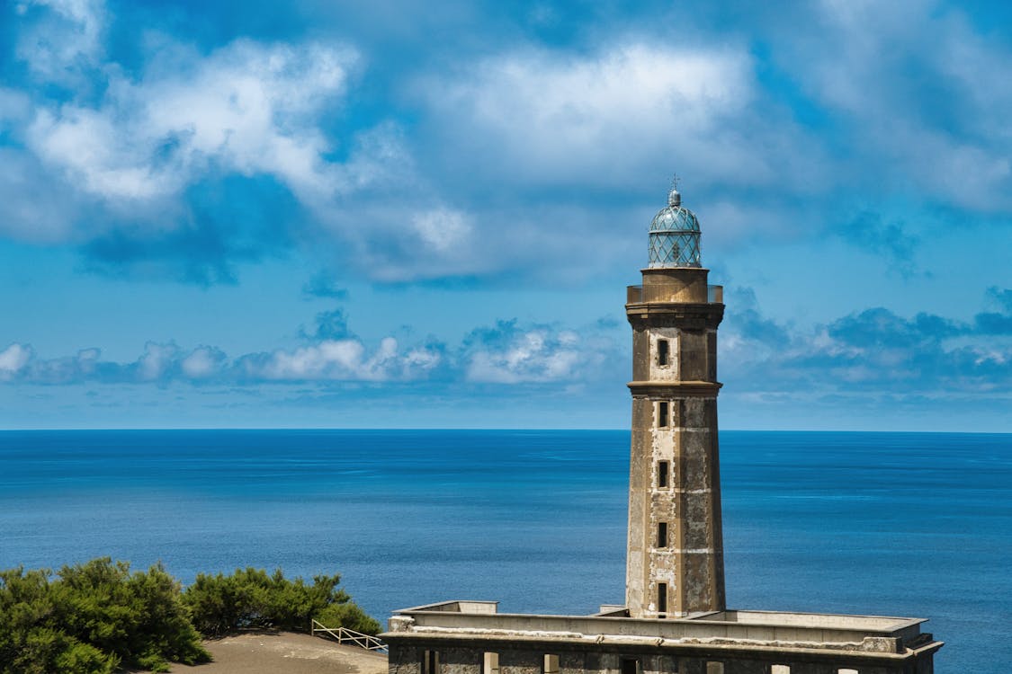 Historic lighthouse in Azores, Portugal against vibrant ocean backdrop