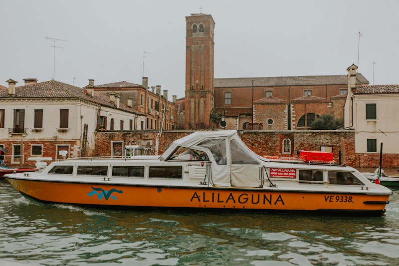 Alilaguna water taxi boat in Venice with historic architecture in background