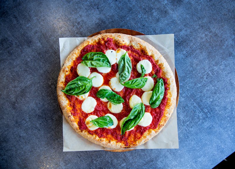 Top view of a classic Margherita pizza with fresh basil and mozzarella