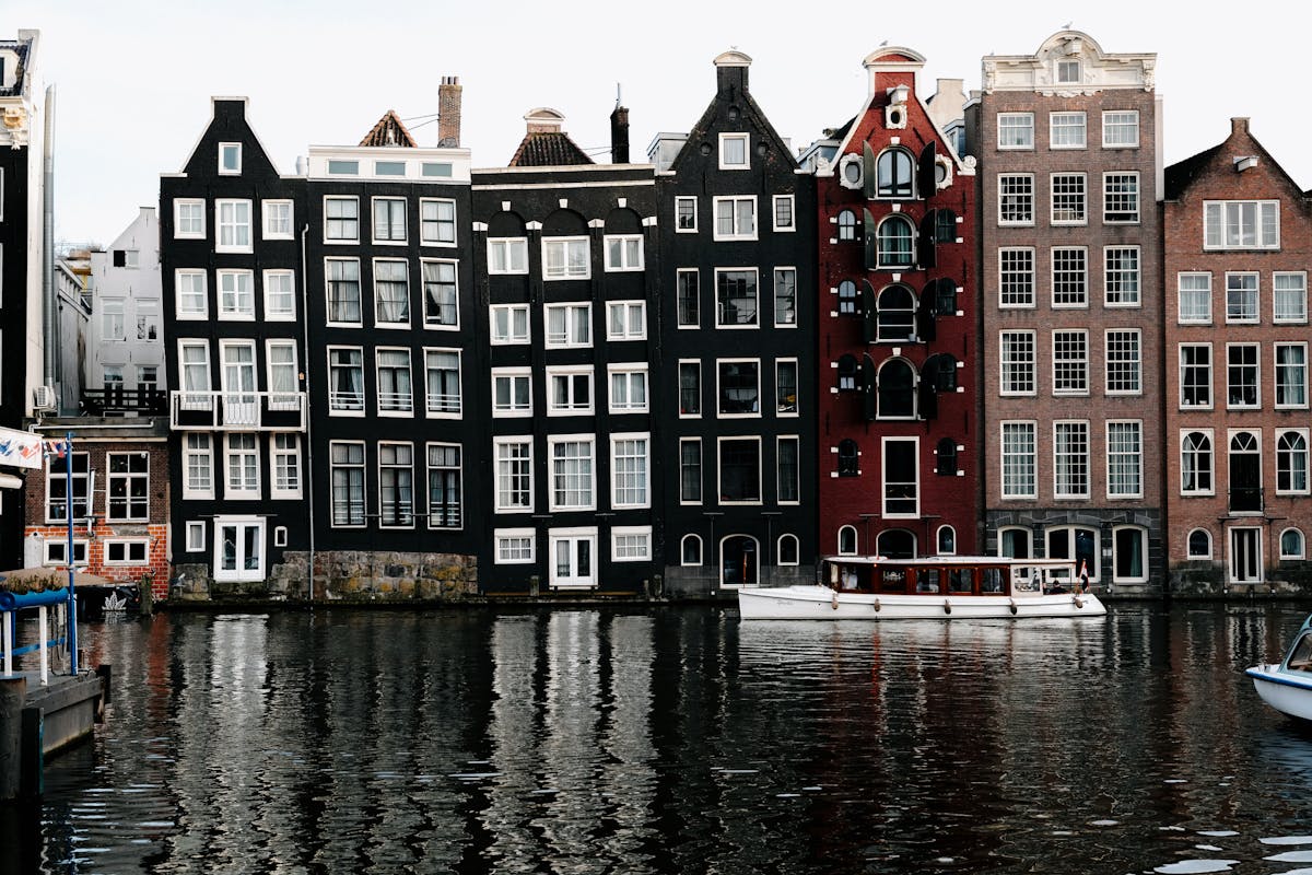 Row of Amsterdam canal houses with reflections on the water