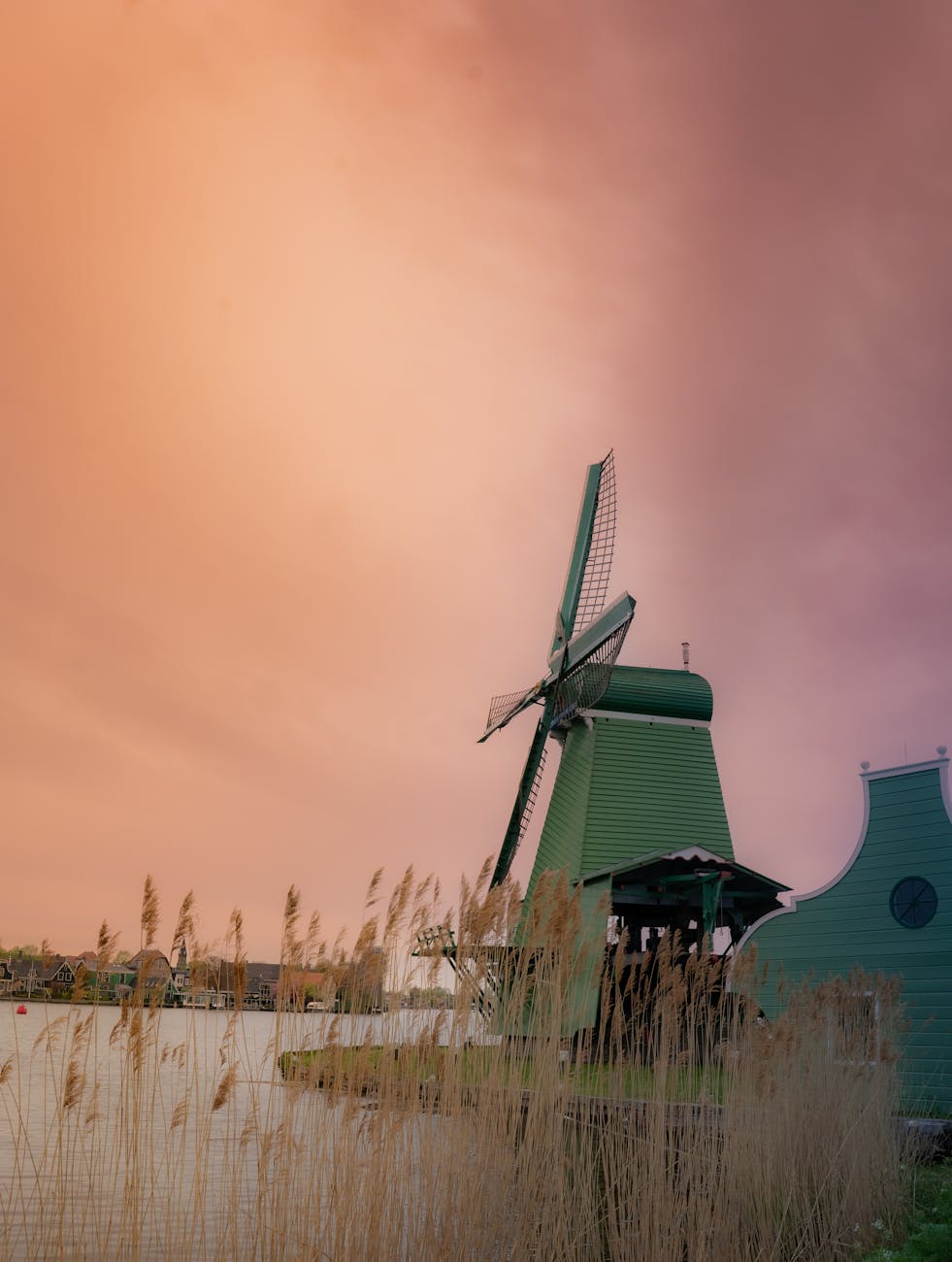 Traditional windmill silhouetted against a colorful sunset sky at Zaanse Schans