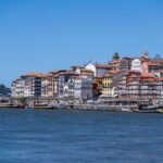 Colorful buildings lining the Ribeira waterfront in Porto with the Douro River in the foreground
