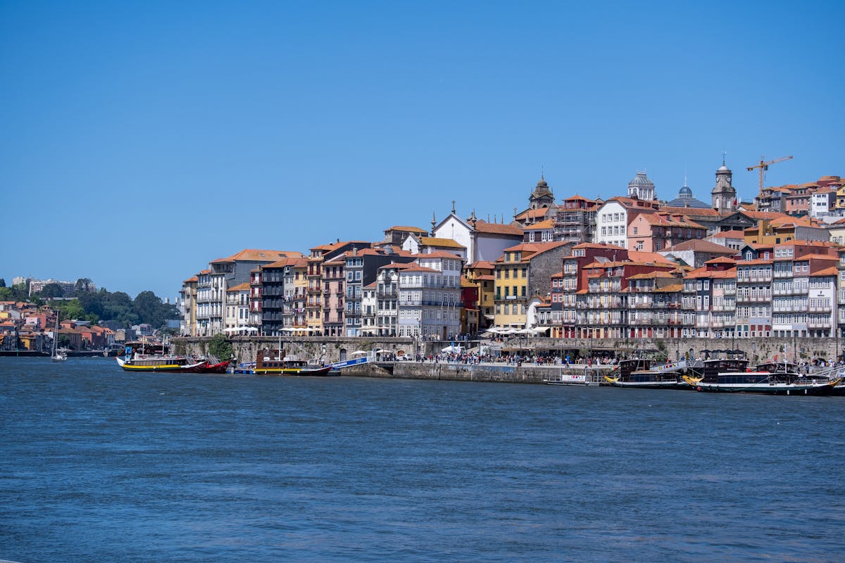 Colorful buildings lining the Ribeira waterfront in Porto with the Douro River in the foreground
