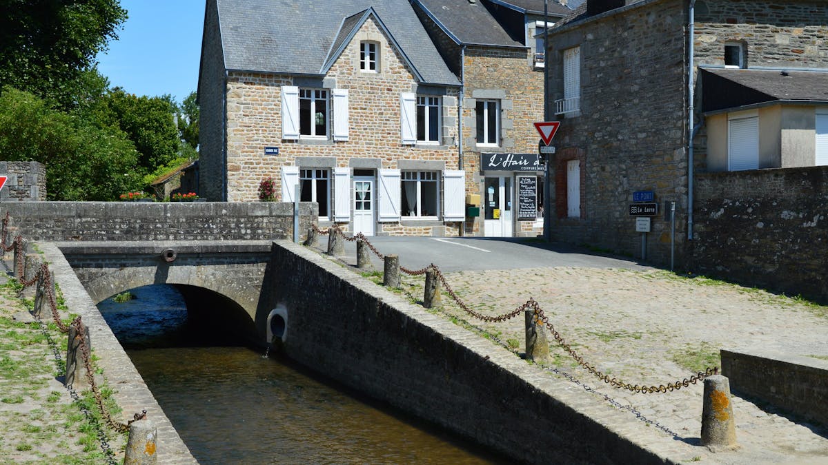 Picturesque stone house by a canal in a Normandy village, France