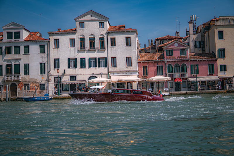 Water taxi cruising through Venice Grand Canal with classic architecture