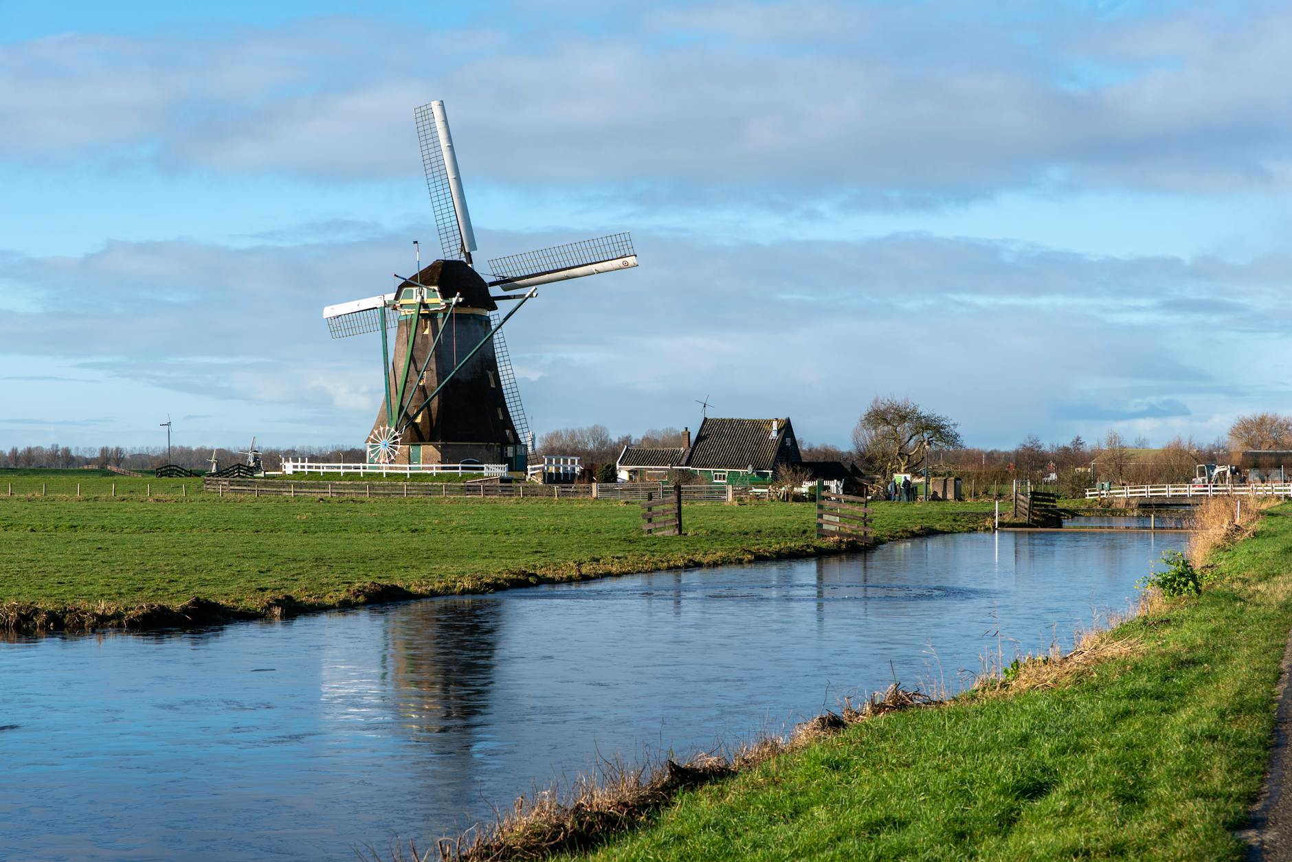 A traditional Dutch windmill beside a serene canal in the countryside
