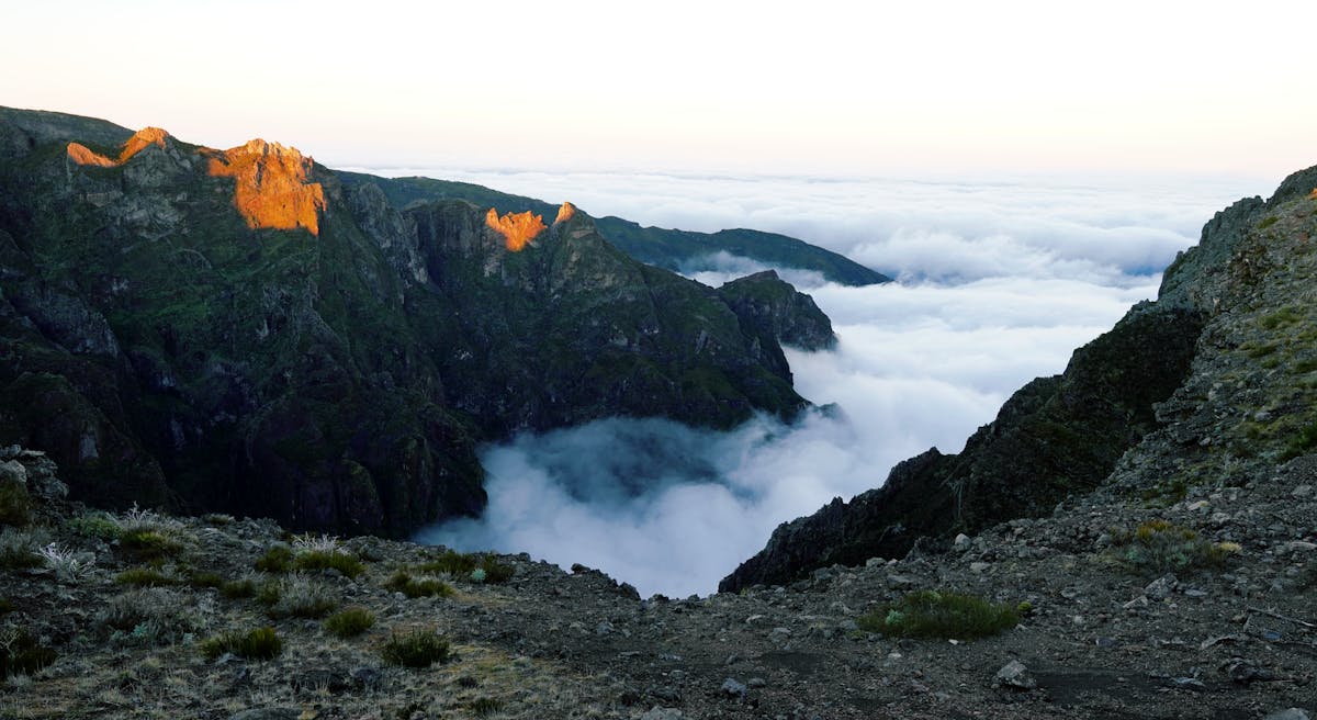 Stunning sunrise view of Madeira mountain peaks above cloud layer